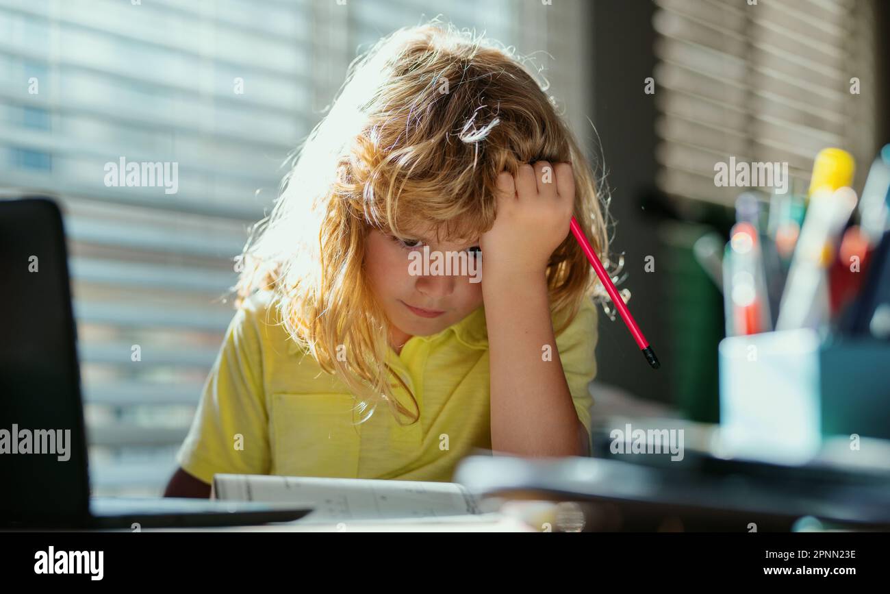Un écolier fatigué en train de faire ses devoirs. Écriture enfant ...