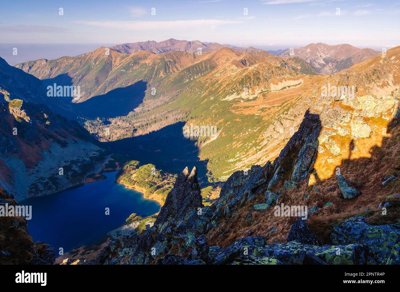 Paysage de montagne avec lac dans la vallée. Silhouette de randonneur ...