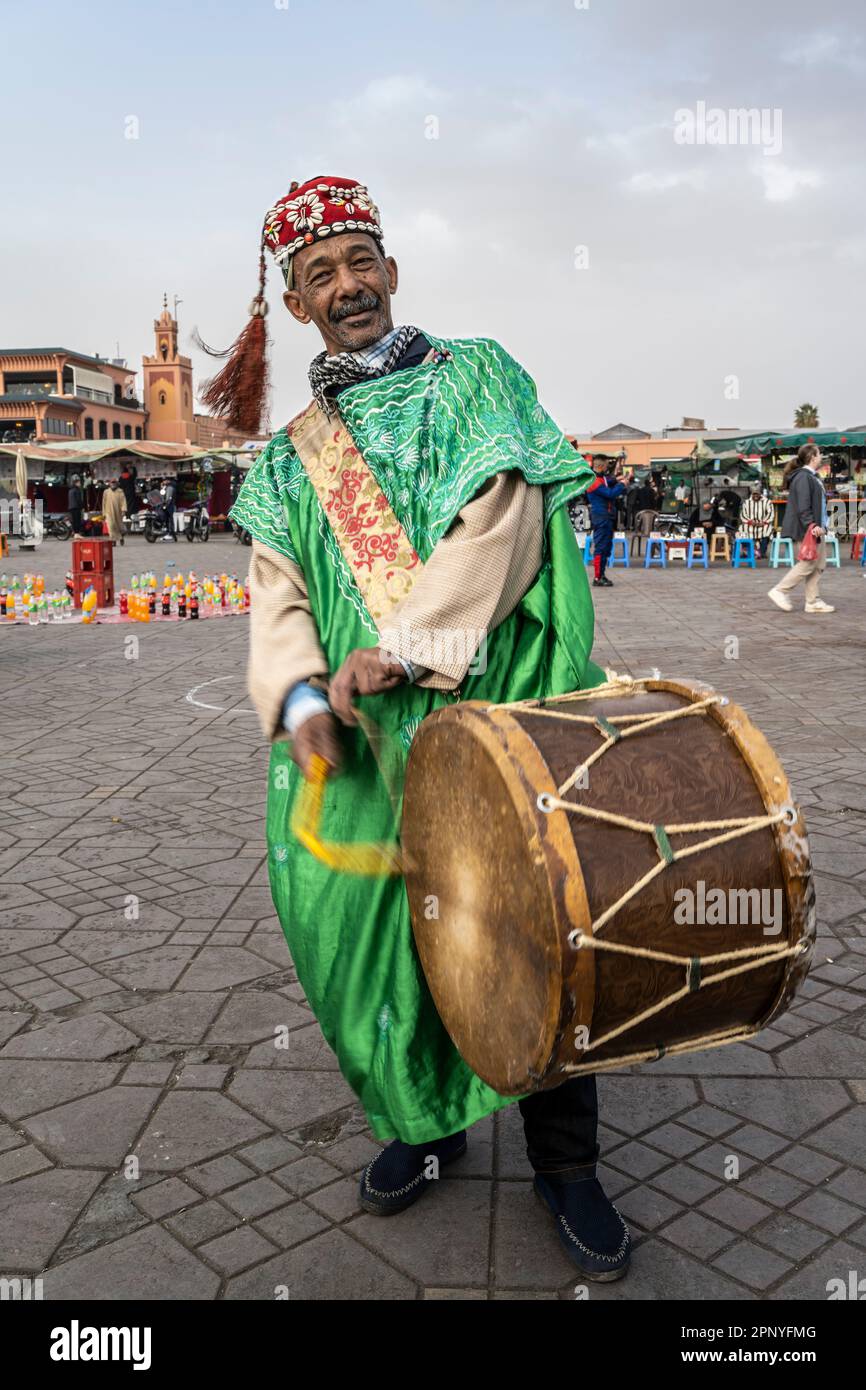 Homme habillé de vêtements traditionnels marocains jouant le tambour ...