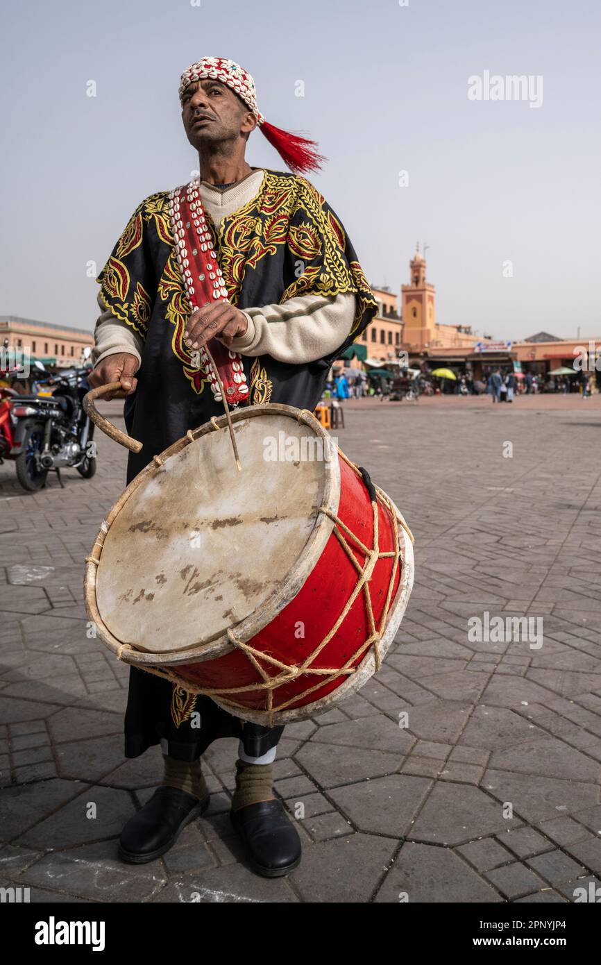 Homme habillé de vêtements traditionnels marocains jouant le tambour ...