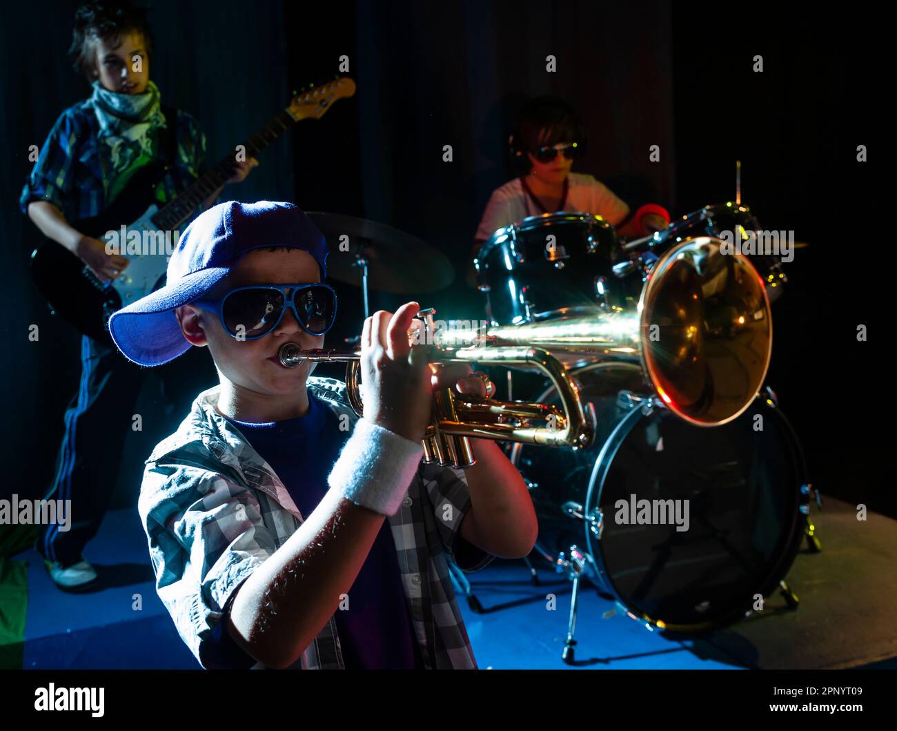 Jeune garçon jouant la trompette avec d'autres bandmates en arrière ...