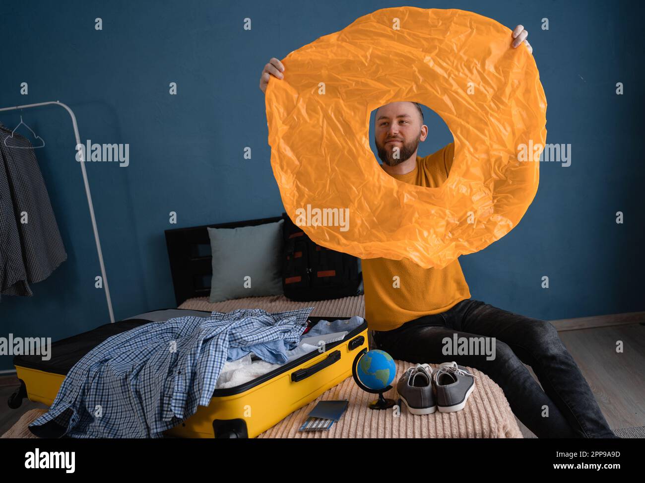 Un homme heureux prêt à voyager avec une valise et un anneau de ...