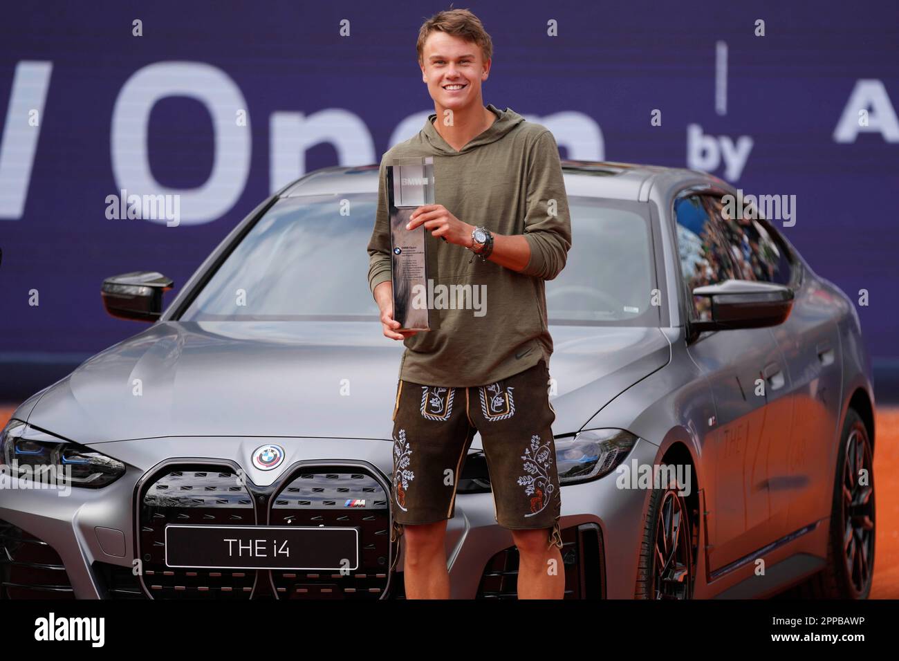 Holger Rune of Denmark poses with the trophy and the BMW i4 winner car ...