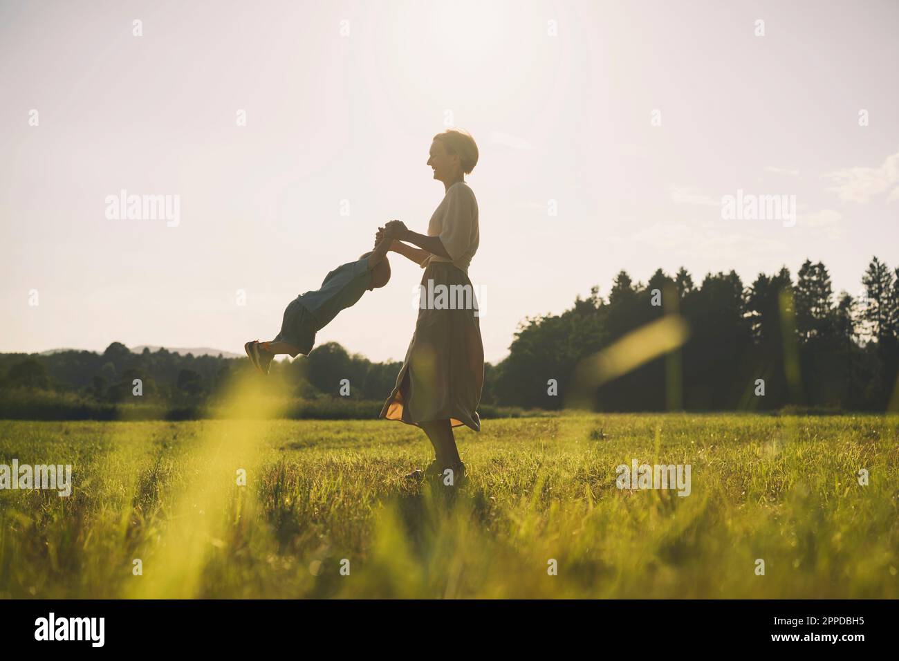 Bonne mère qui tourne son fils et qui s'amuse dans la nature Photo ...