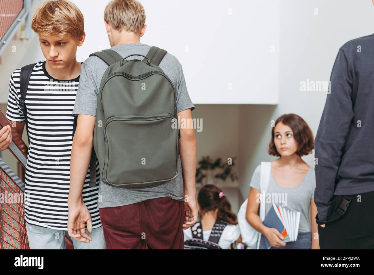 Un jeune garçon taquinait avec un ami dans un couloir d'école en ...