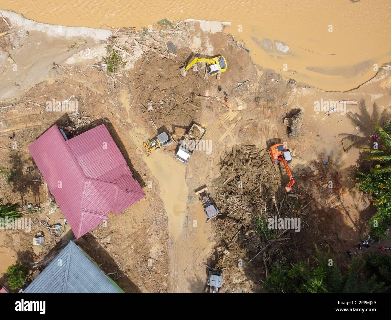 Excavatrice et camion de vue aérienne dégagent les débris et la boue de ...