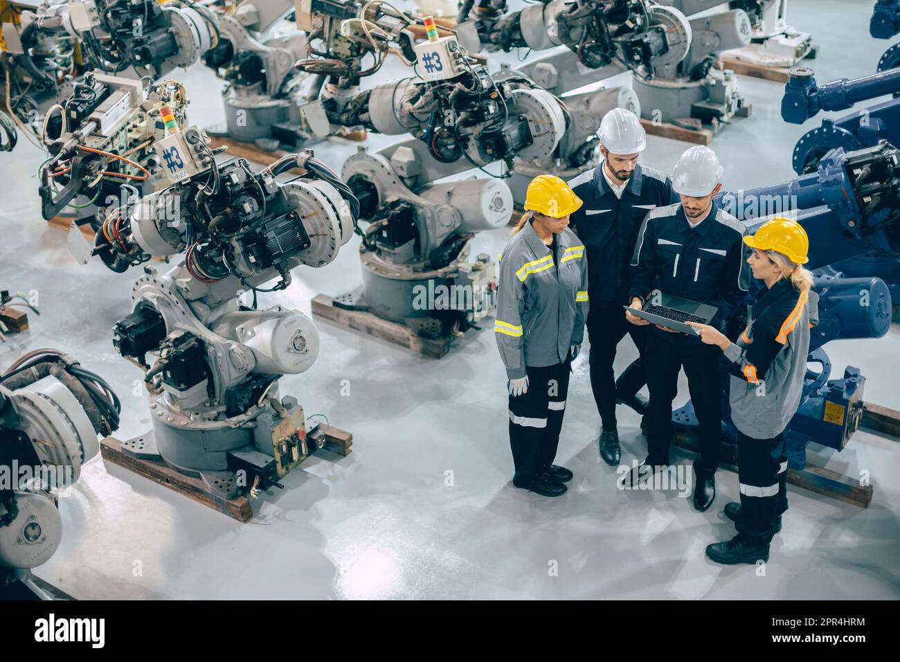 Équipe d'ingénieurs divers travaillant ensemble dans une usine moderne ...