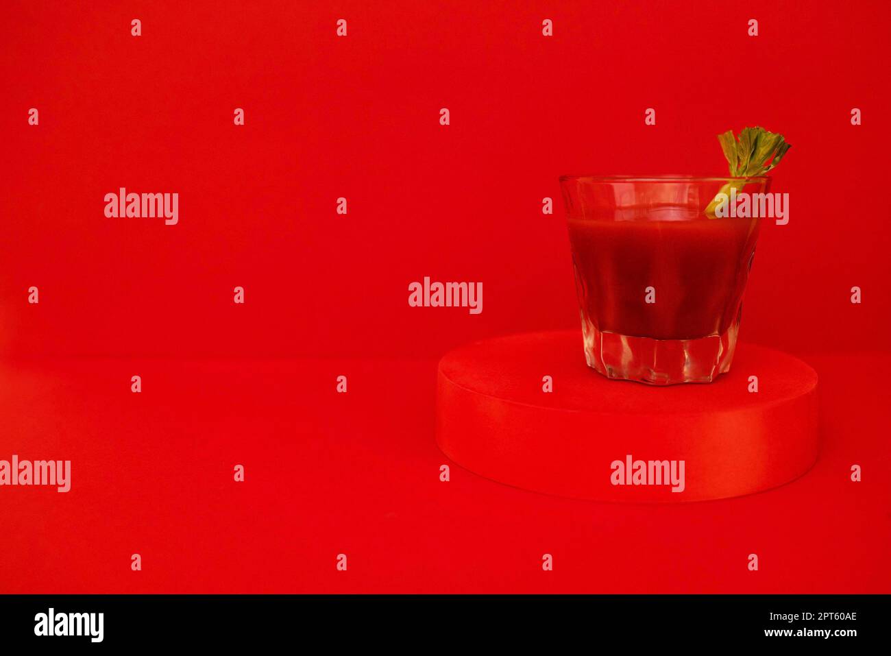 Un verre de cocktail rouge avec des verts sur le podium. Boisson ...