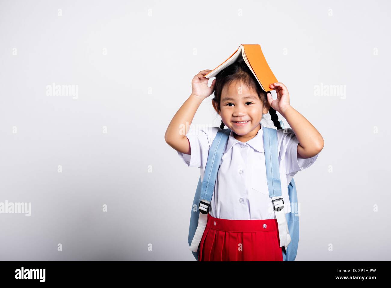 Asiatique adorable tout-petit souriant heureux portant étudiant thaïlandais uniforme rouge jupe ...