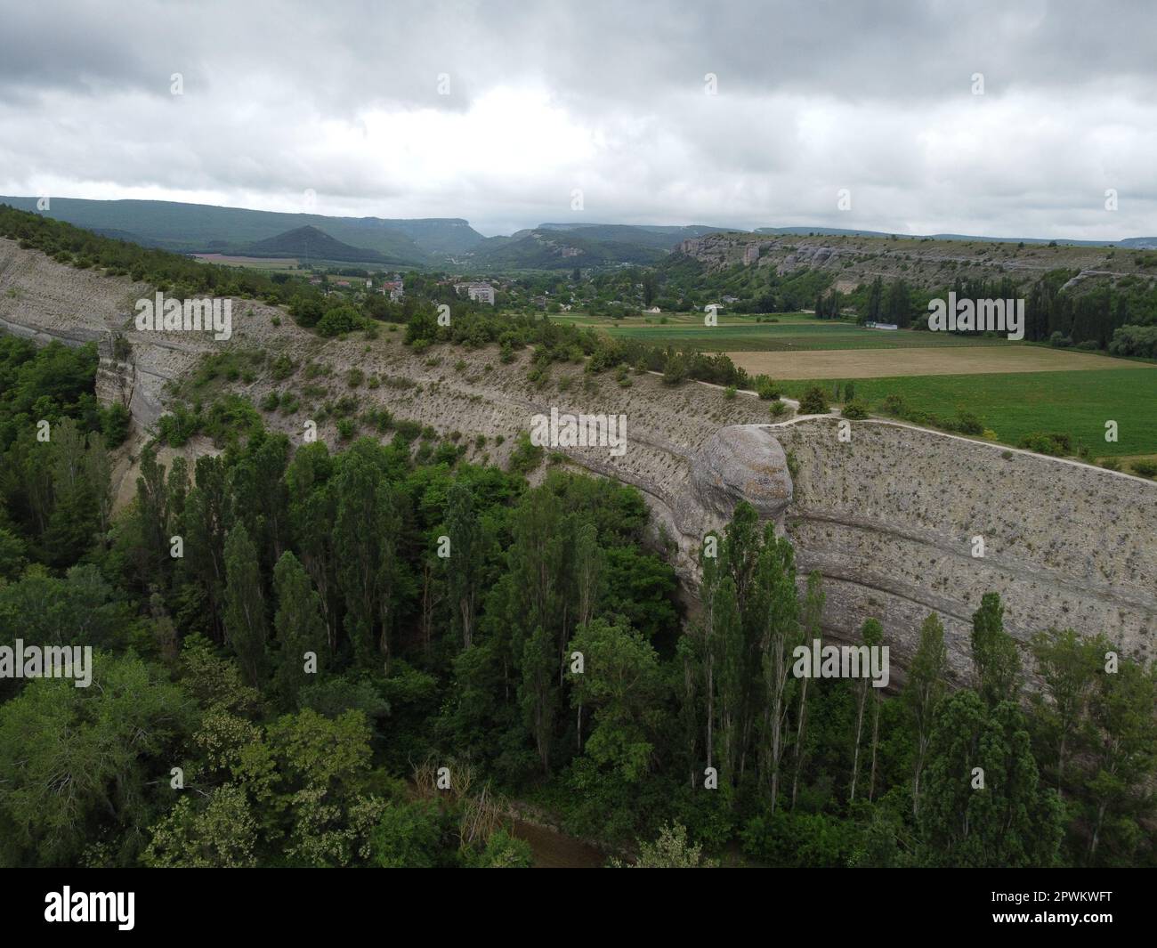 Viev aérien de la ferme verdoyante avec des falaises rocheuses au loin ...