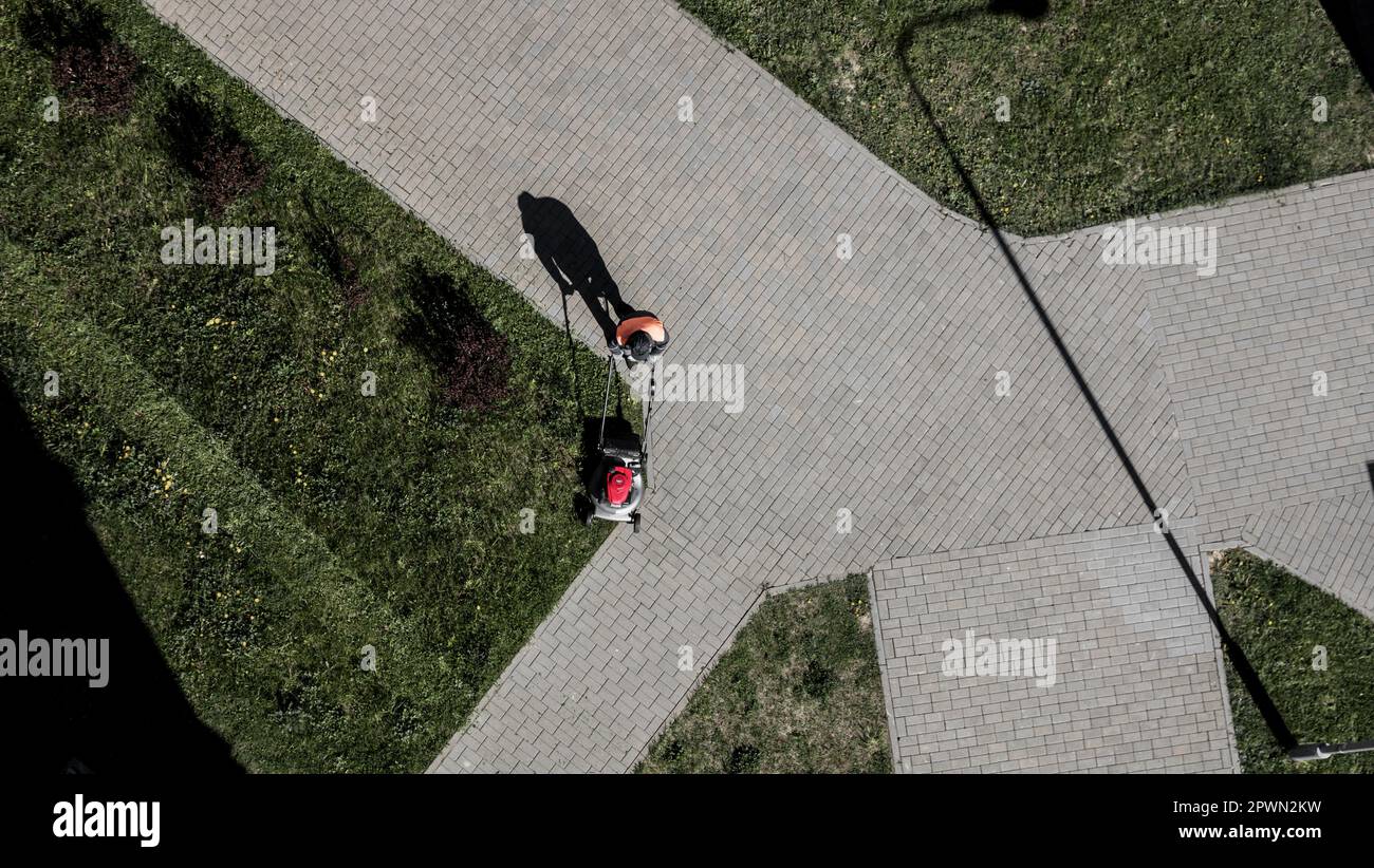 l'homme tond une pelouse. Un jardinier professionnel équipé d'un robot ...