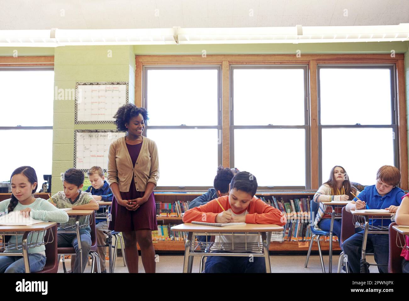 Évaluer leurs progrès. une enseignante dans une salle de classe avec ...