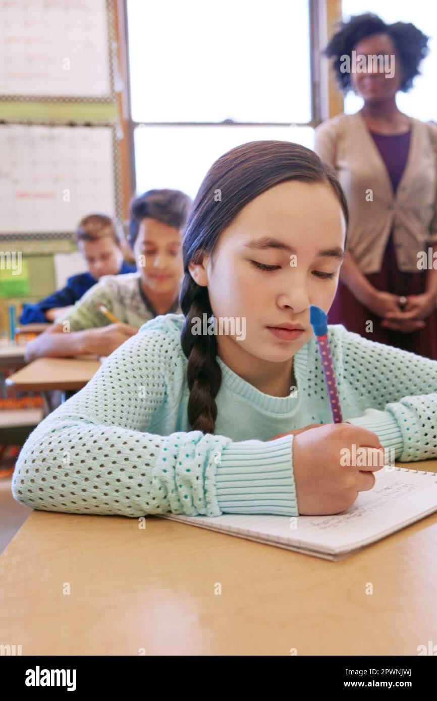 Shes s'est concentré sur ce test. une jeune fille assise en classe avec ...