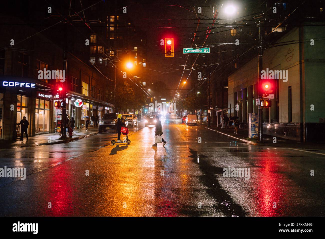 Une rue animée de la ville la nuit éclairée par les feux de rue et les ...