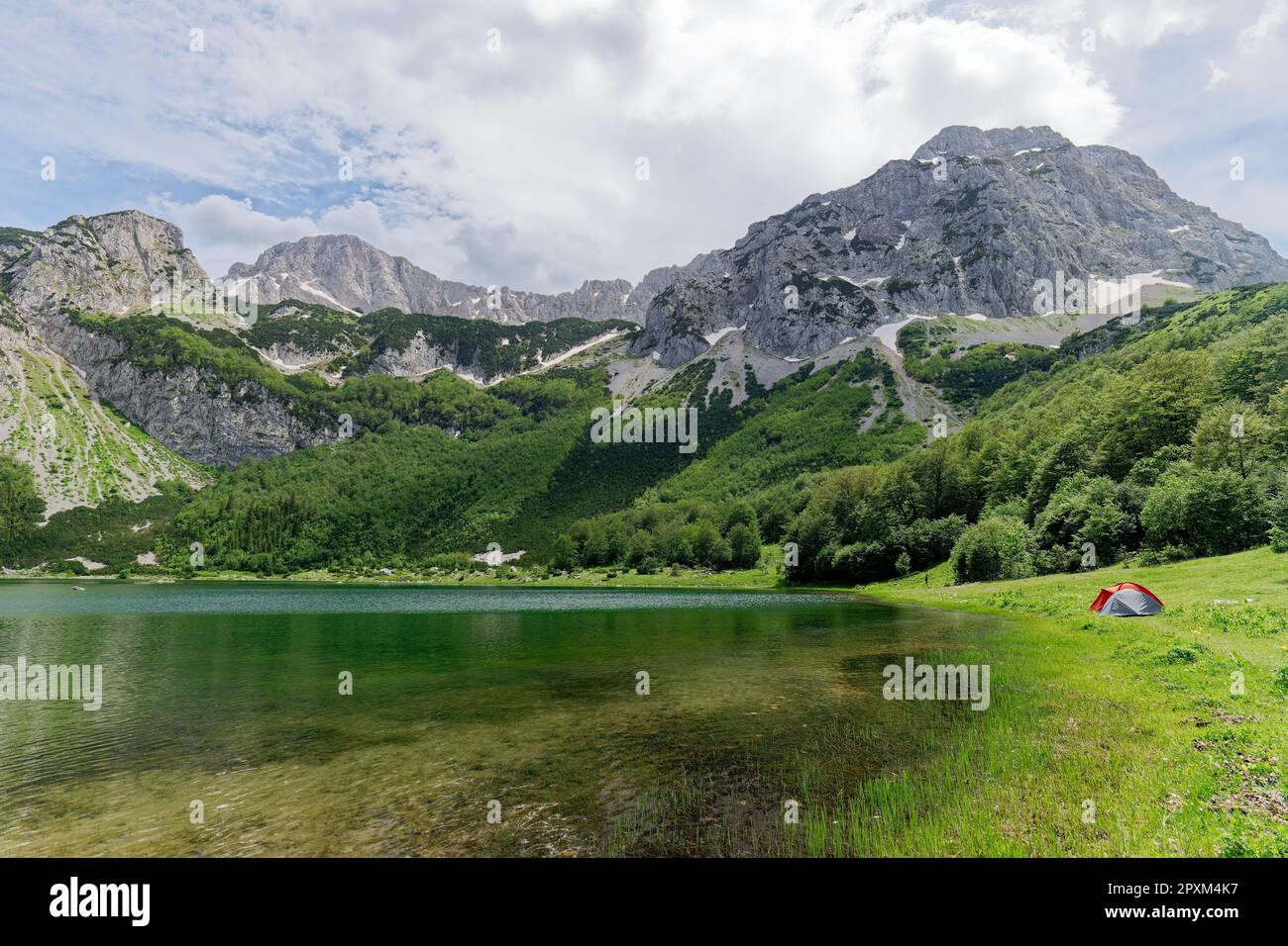 Camping à côté d'un lac entouré de montagnes. Vue magnifique et ...