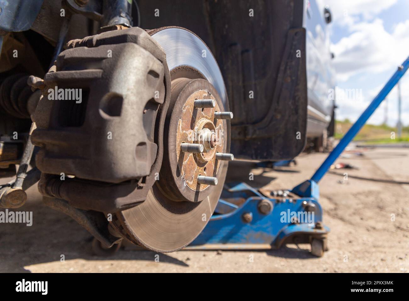 Voiture sur montage de pneu avec roue déposée sur cric pneumatique ...