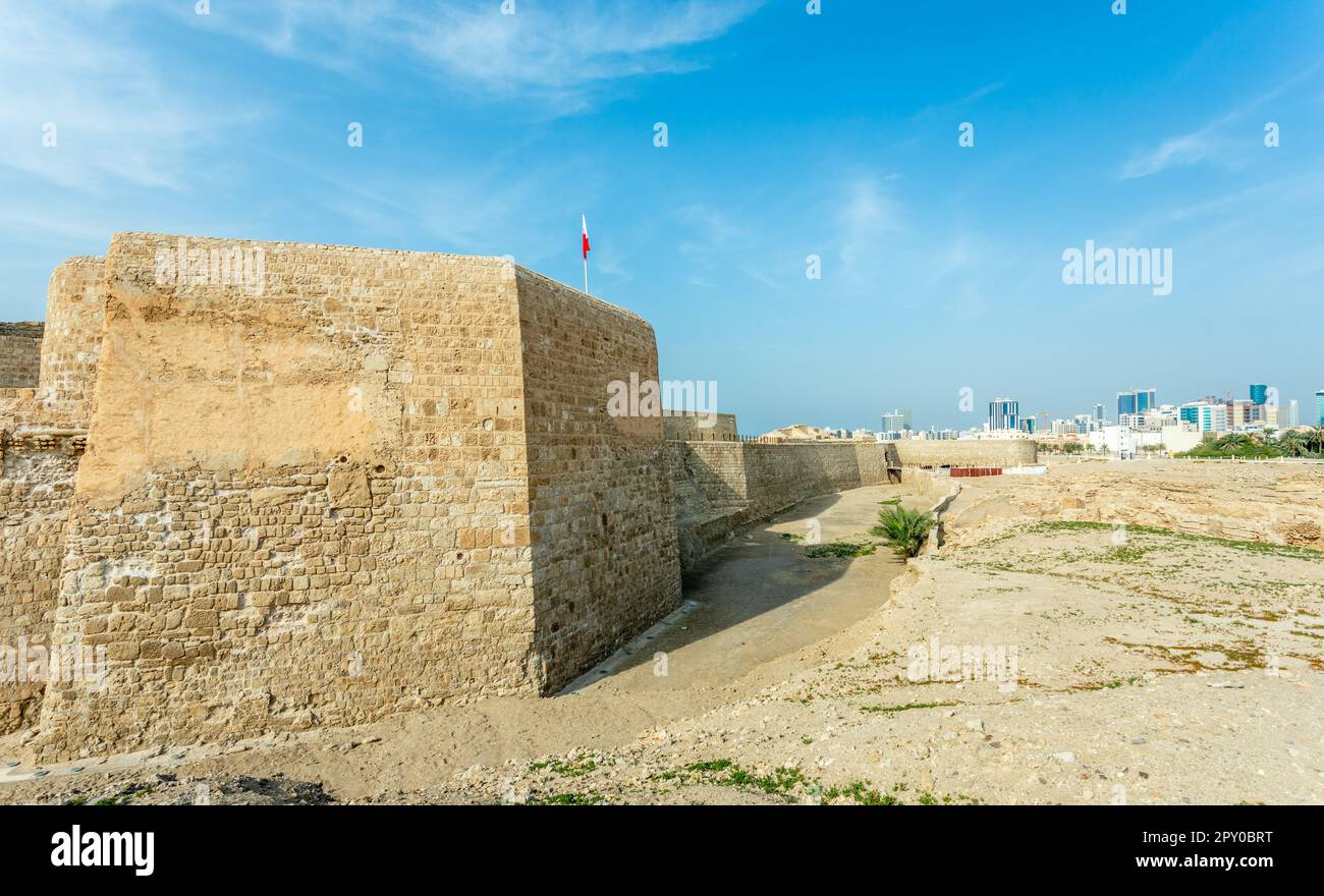 Ruines de la forteresse portugaise de Qalat al-Bahreïn avec le centre-ville en arrière-plan ...