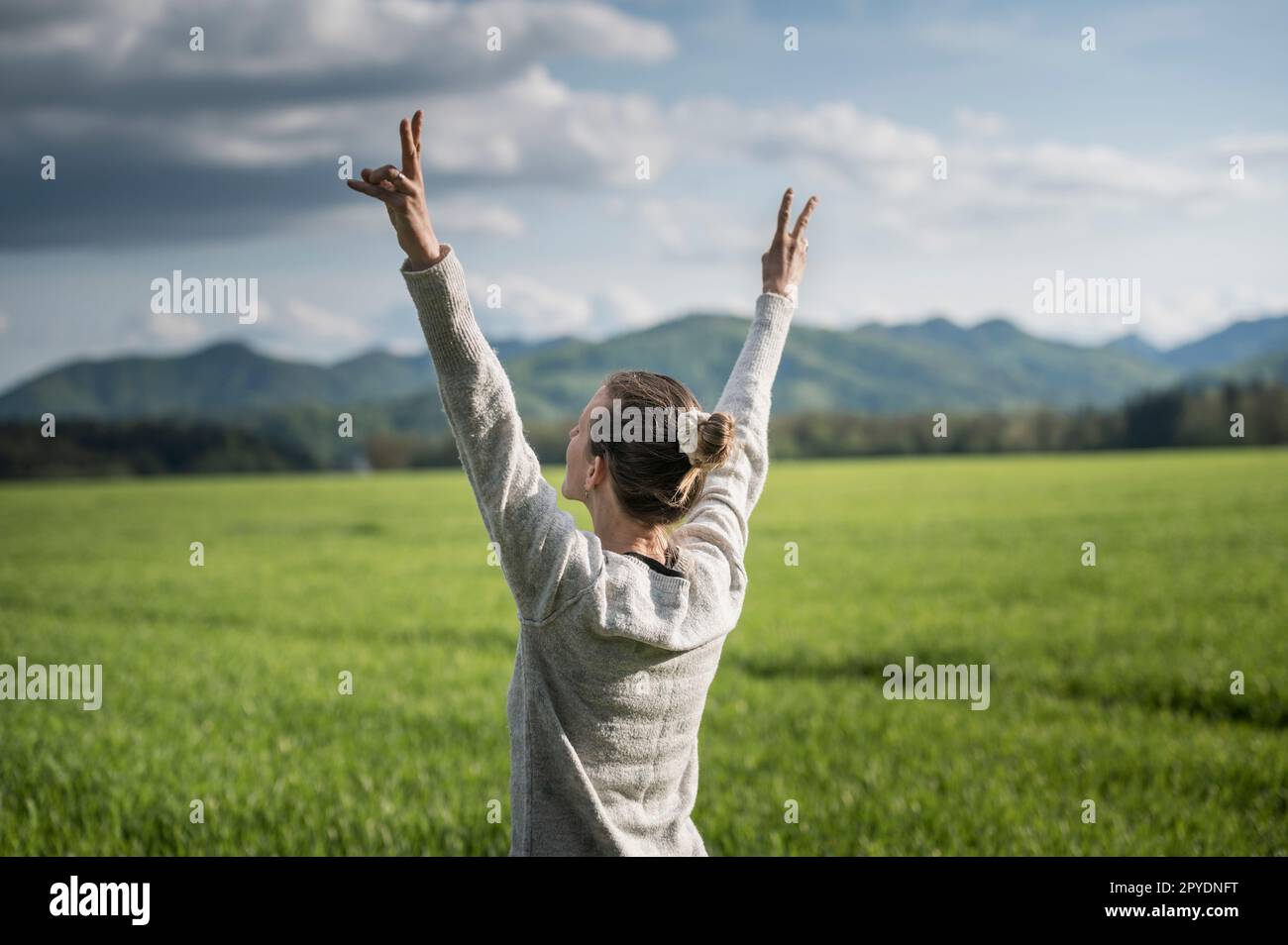 Femme célébrant la vie et l'accomplissement debout avec ses bras dans ...