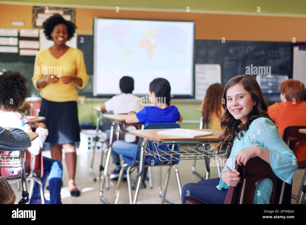 Apprendre les bases. une jeune fille assise en classe avec son ...