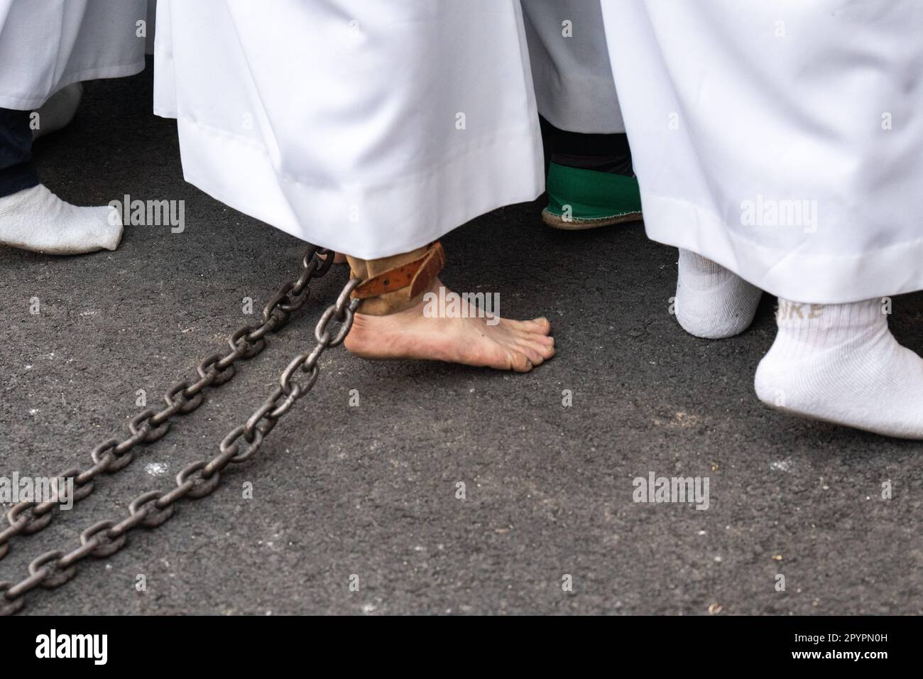Un Nazareno barré tire une chaîne de sa cheville comme il porte une ...
