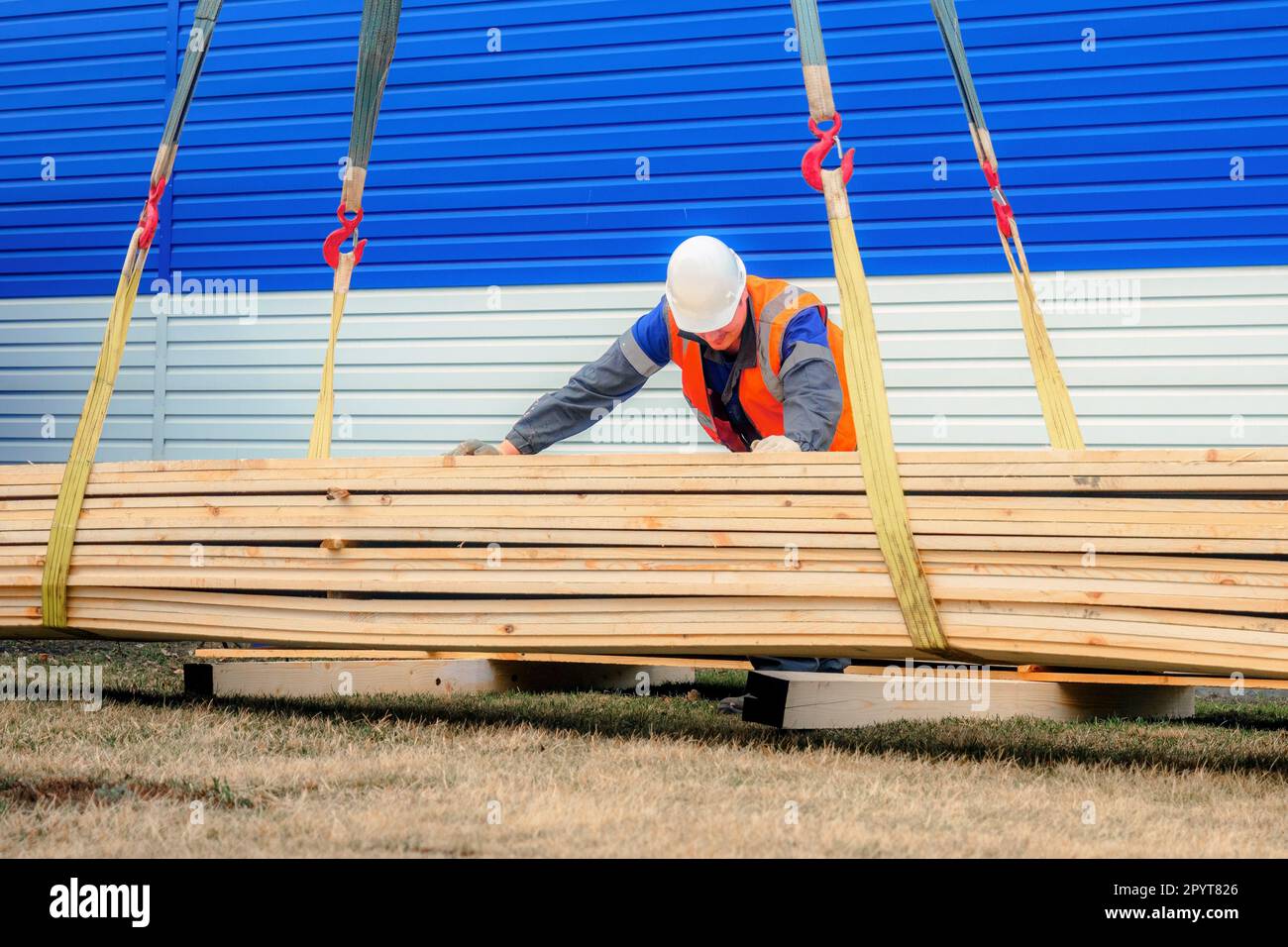 Le slinger dans le casque et le gilet de signalisation décharge les ...