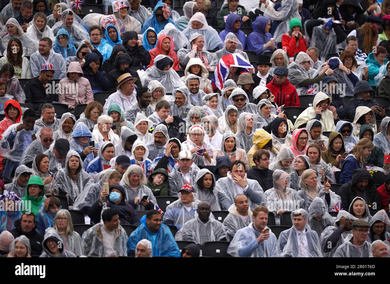 Les foules portant des ponchos de pluie dans la tribune en face de ...
