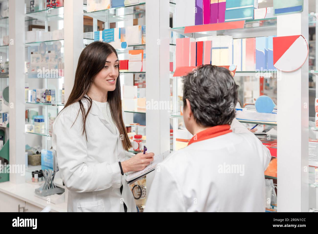 Les jeunes femmes pharmaciens sont heureuses, en uniforme médical blanc, souriant et prenant des ...