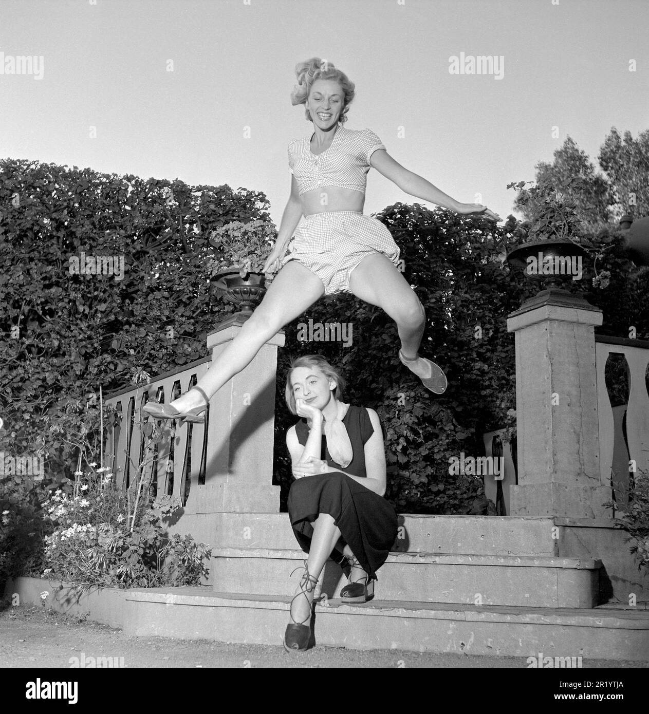 Jeune femme assise dans les escaliers Banque d'images noir et blanc - Alamy