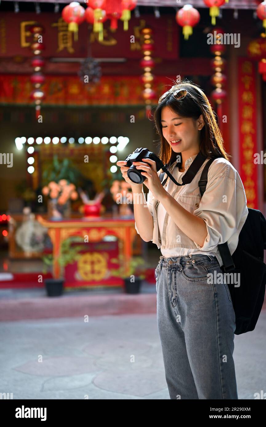 Portrait d'une jeune touriste charmante et heureuse qui vérifie des ...