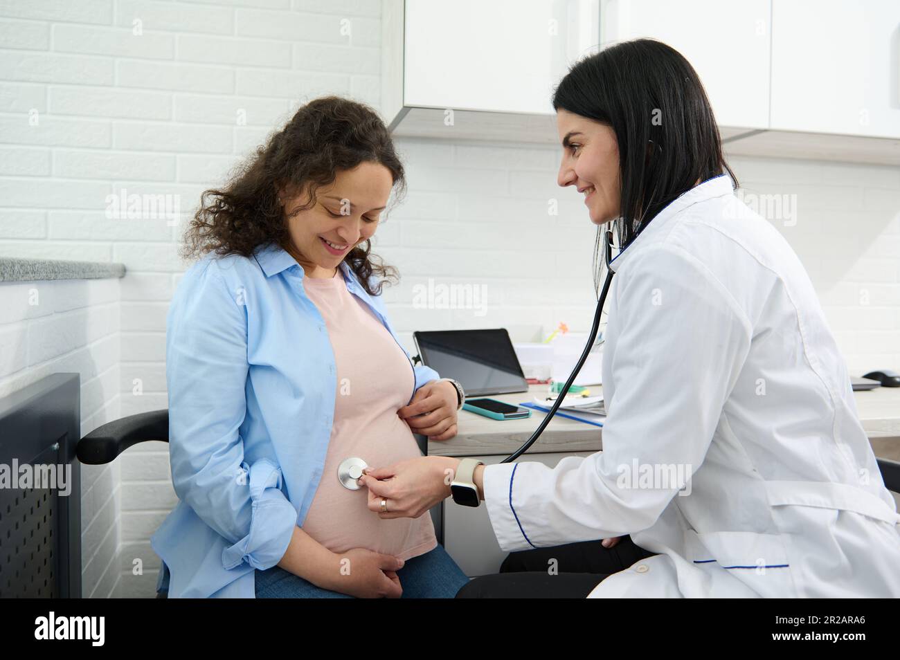 La femme médecin obstétricienne gynécologue vérifie le rythme cardiaque ...