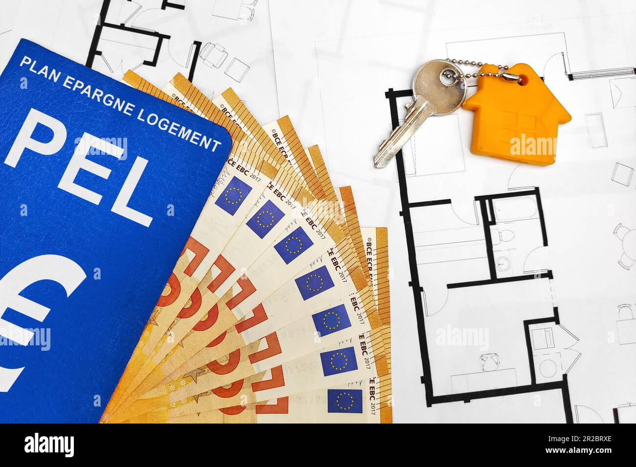 PEL rempli de billets en euros au-dessus d'une pile de plans. Le Plan ... PEL rempli de billets en euros au-dessus d'une pile de plans. Le Plan ...