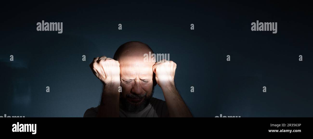 Homme dans son 50s, secoué émotionnellement montrant le stress ou le ...