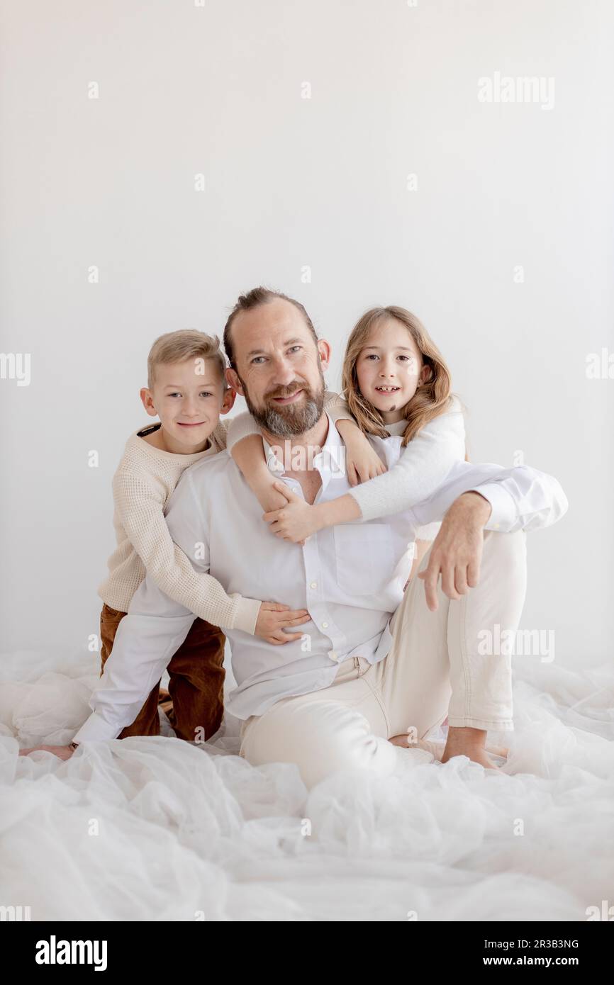 Père Avec Son Fils Et Sa Fille Assis Devant Le Mur Photo Stock Alamy