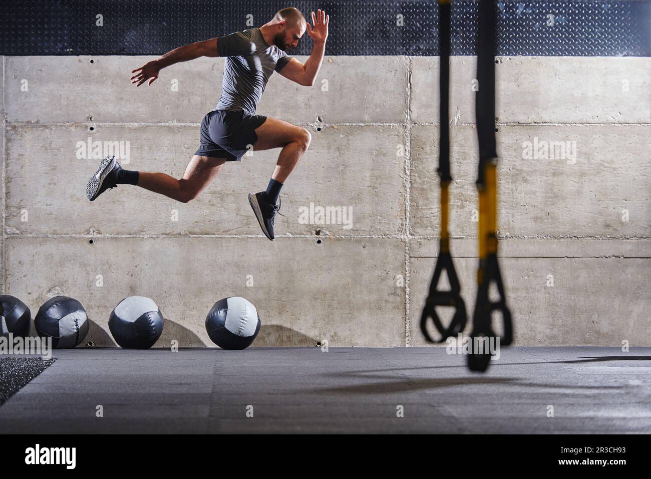 Un homme musclé capturé dans l'air alors qu'il saute dans une salle de ...