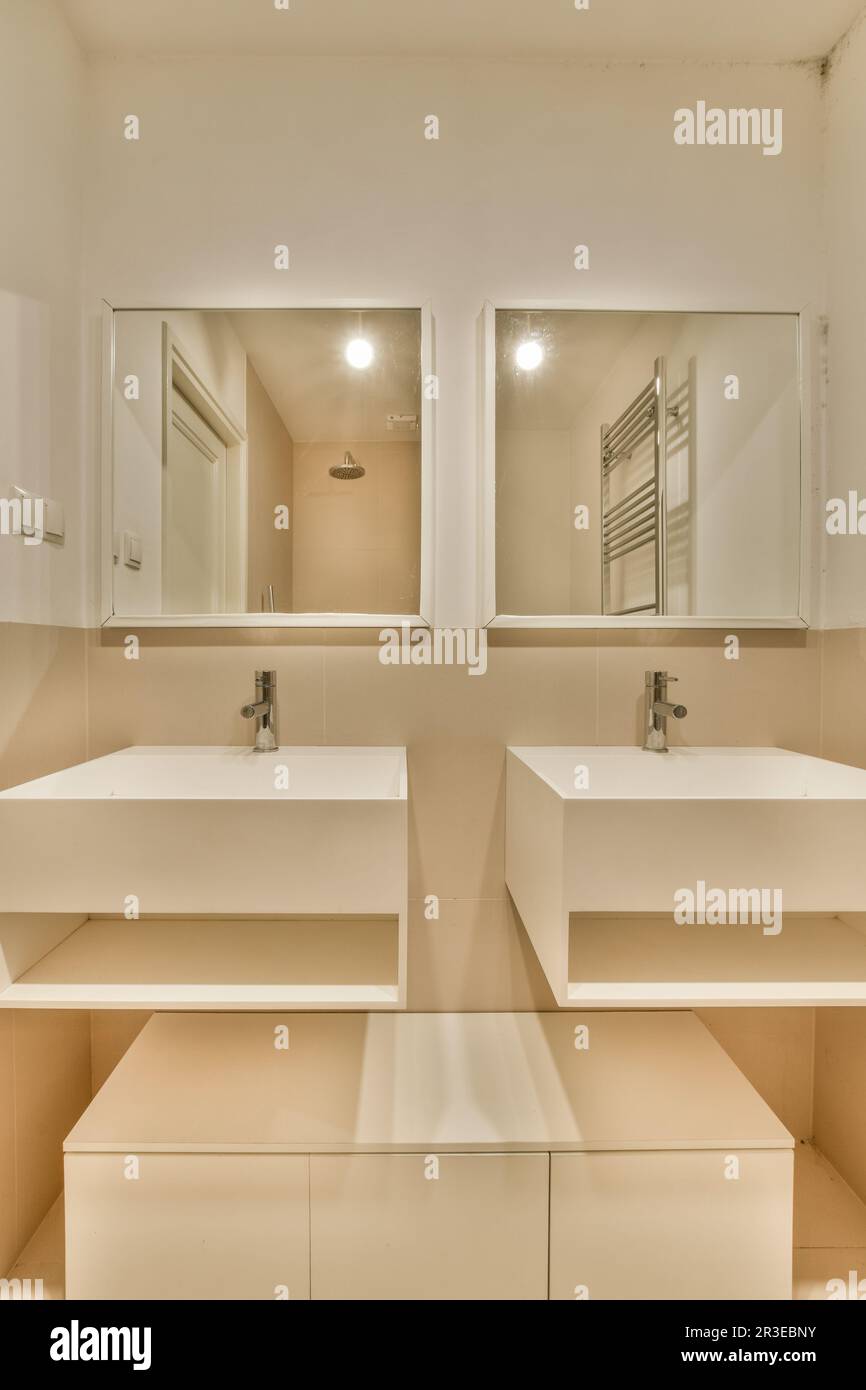 deux lavabos dans une salle de bains avec miroirs au mur et un lavabo ...