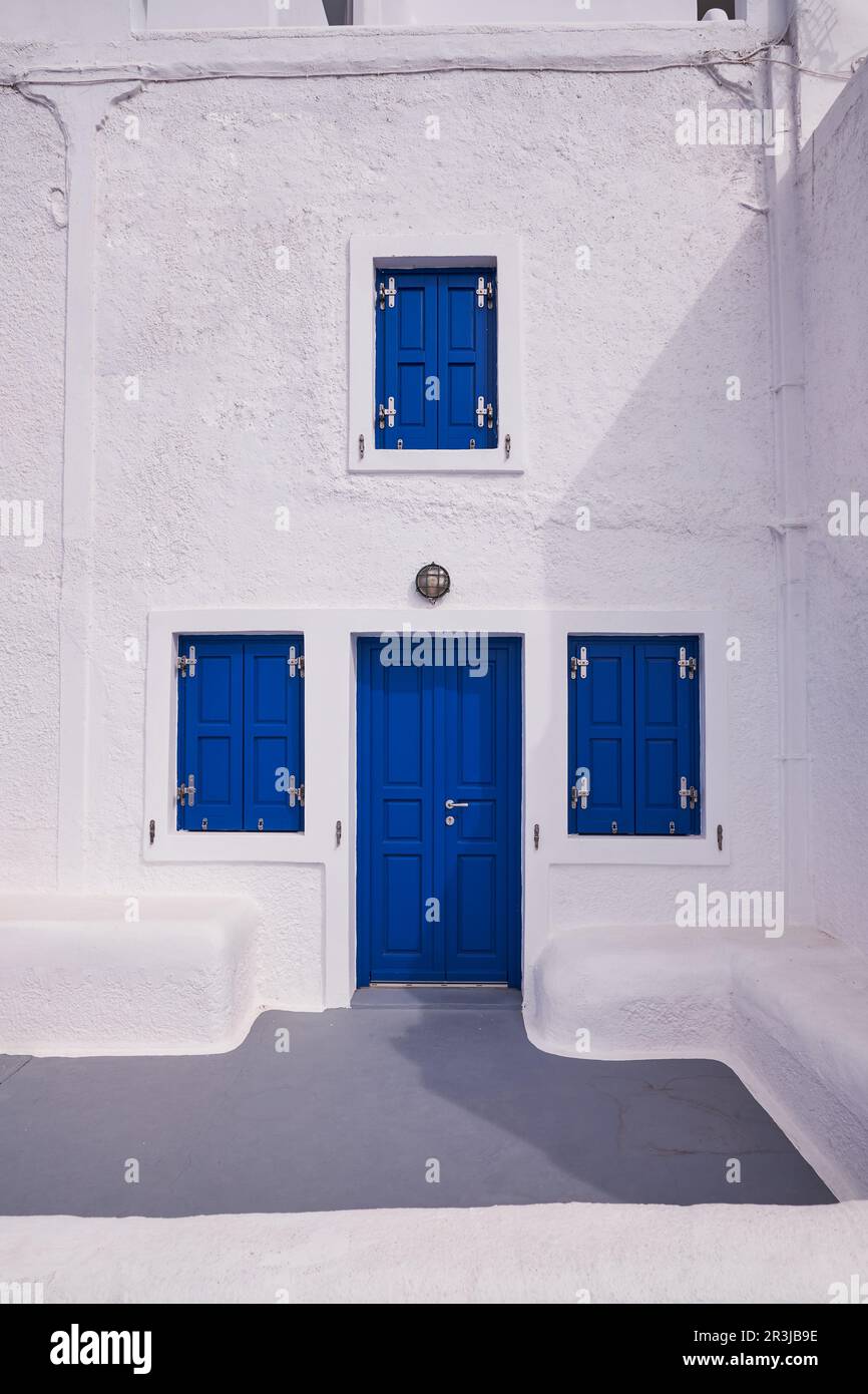 Maison blanche grecque traditionnelle avec des fenêtres bleues et porte ...