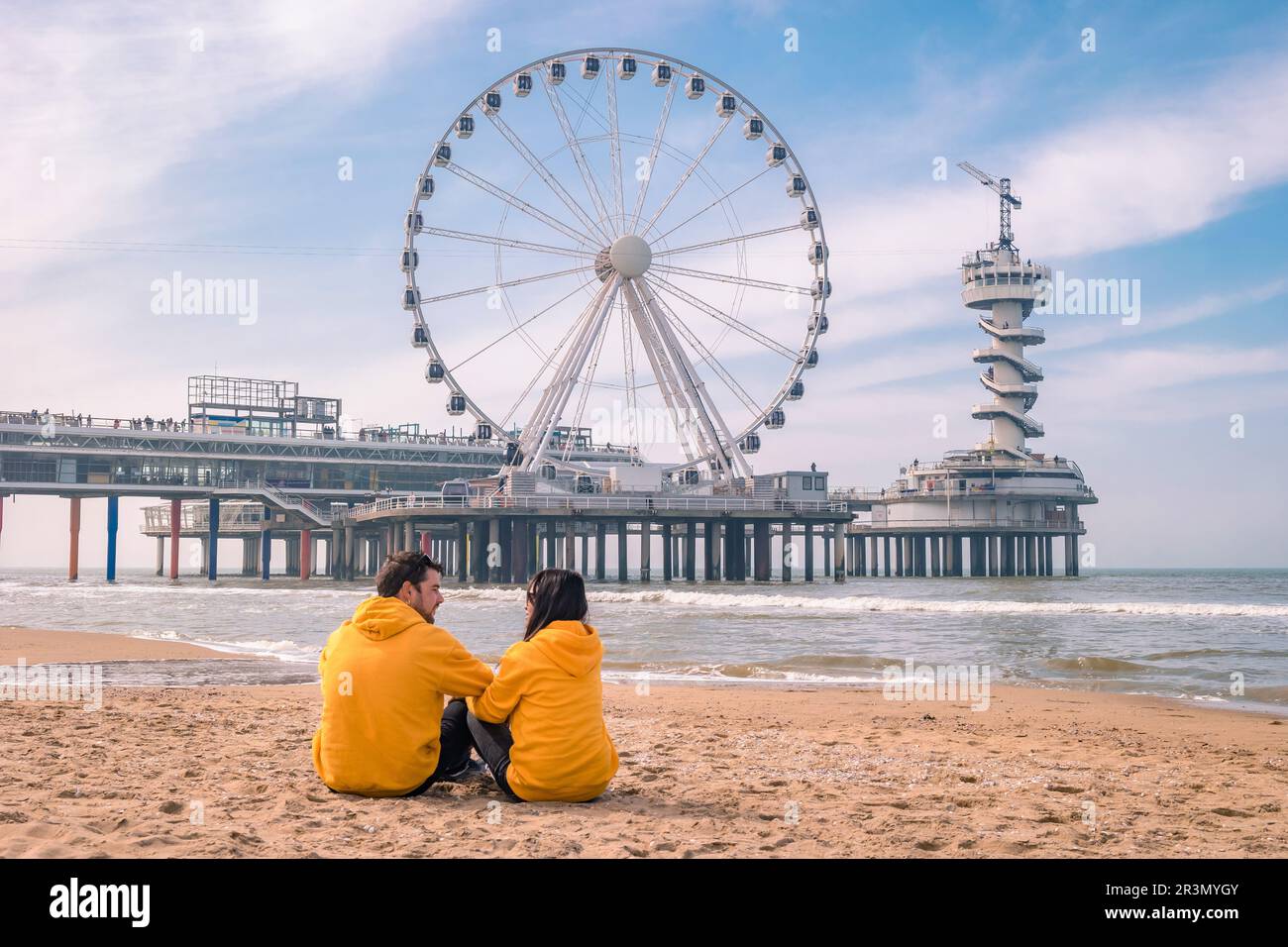 Couple sur la plage de Scheveningen pays-Bas pendant le printemps, la grande roue à la jetée de ...