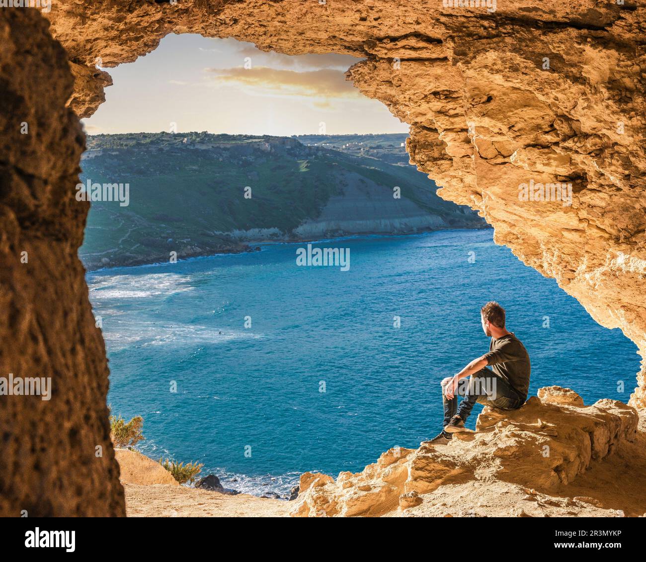 Gozo île de Malte, jeune homme dans une grotte qui donne sur l'océan ...