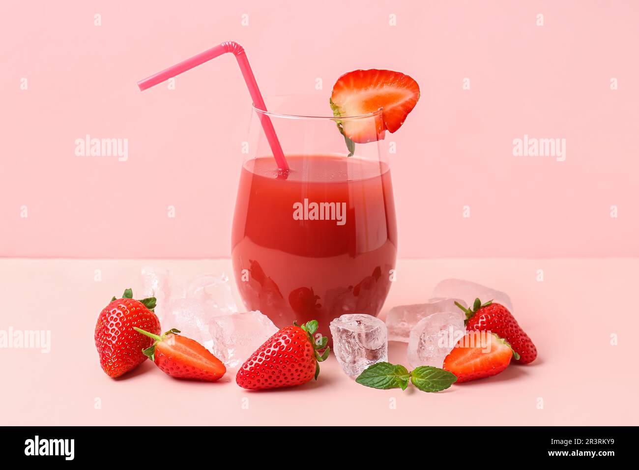 Verre de délicieux jus de fraise avec glaçons sur table blanche Photo ...