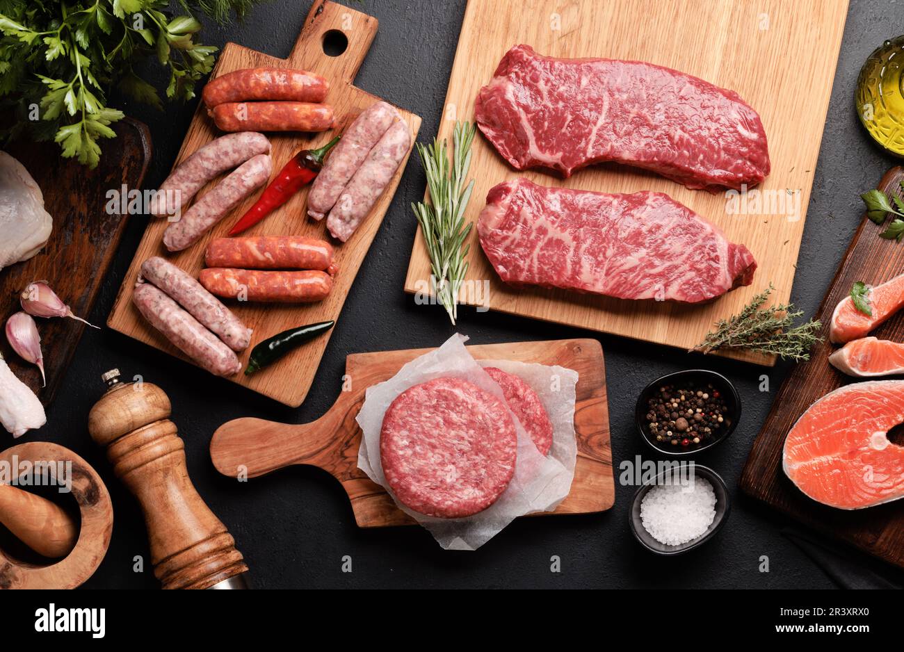 Diverses viandes et poissons crus. Steaks, saucisses, saumon, poulet et ...