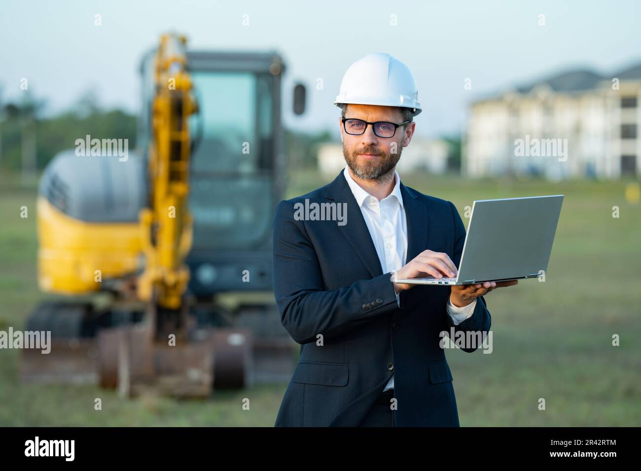 Directeur de construction en costume et casque sur un chantier de construction. Un employé ou un ...