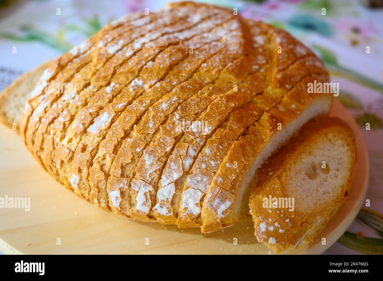 Gros pain rond frais fait de farine de blé blanc en tranches de gros ...