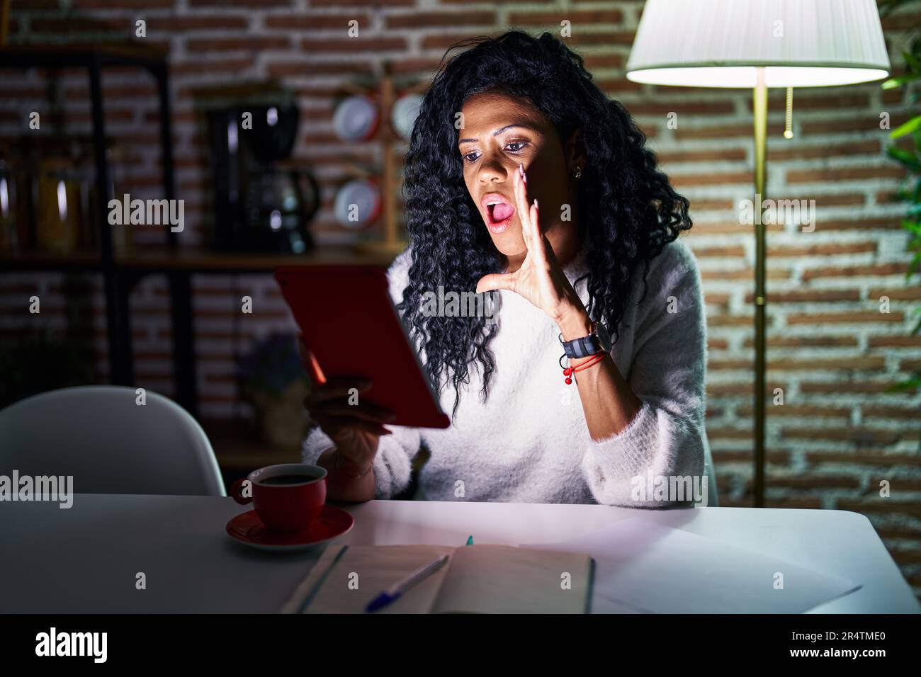 Femme hispanique d'âge moyen utilisant le pavé tactile assis sur la ...