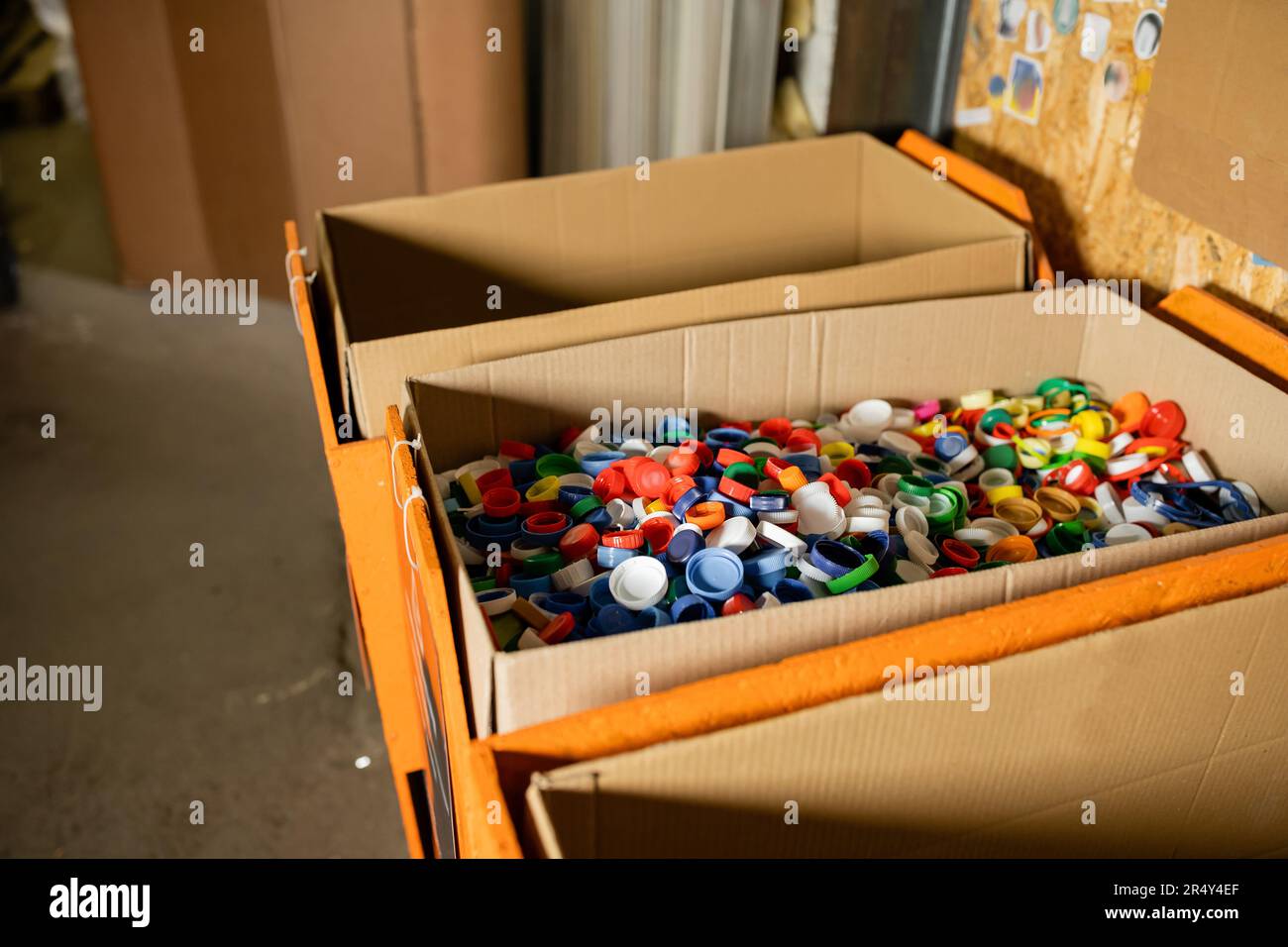 Boîtes en carton avec bouchons en plastique colorés pour le recyclage ...