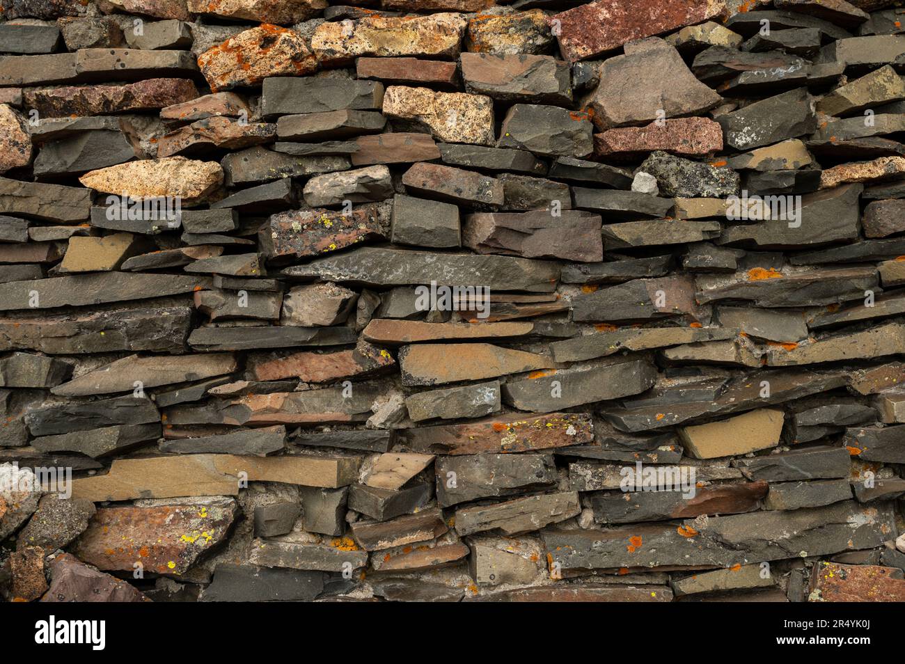 Mur en pierre empilée recouvert de taches orange sur le mur de ...