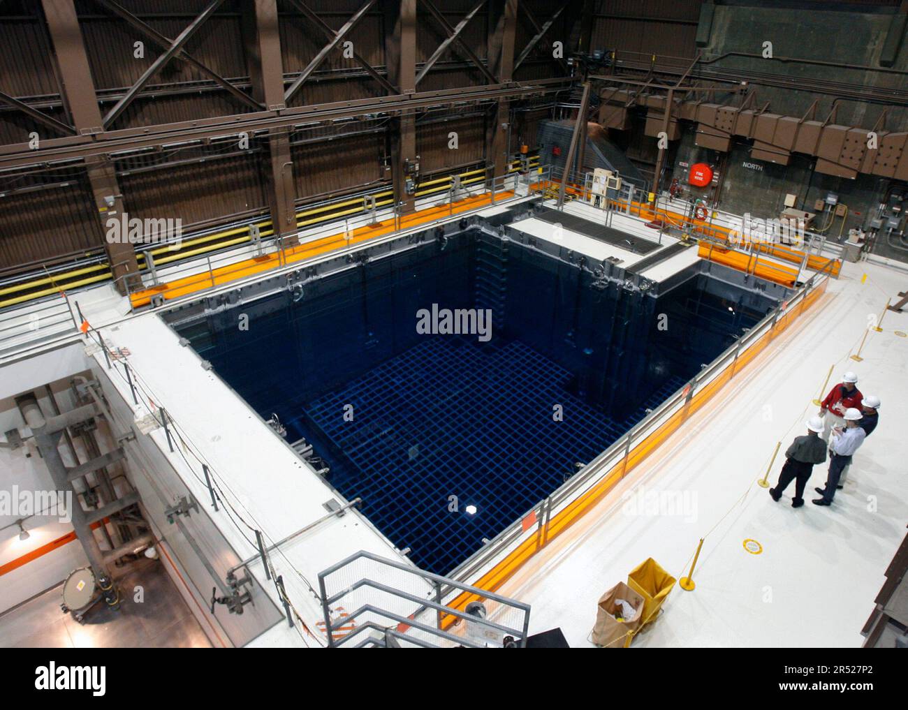 Power plant officials stand near the edge of one of two spent fuel ...