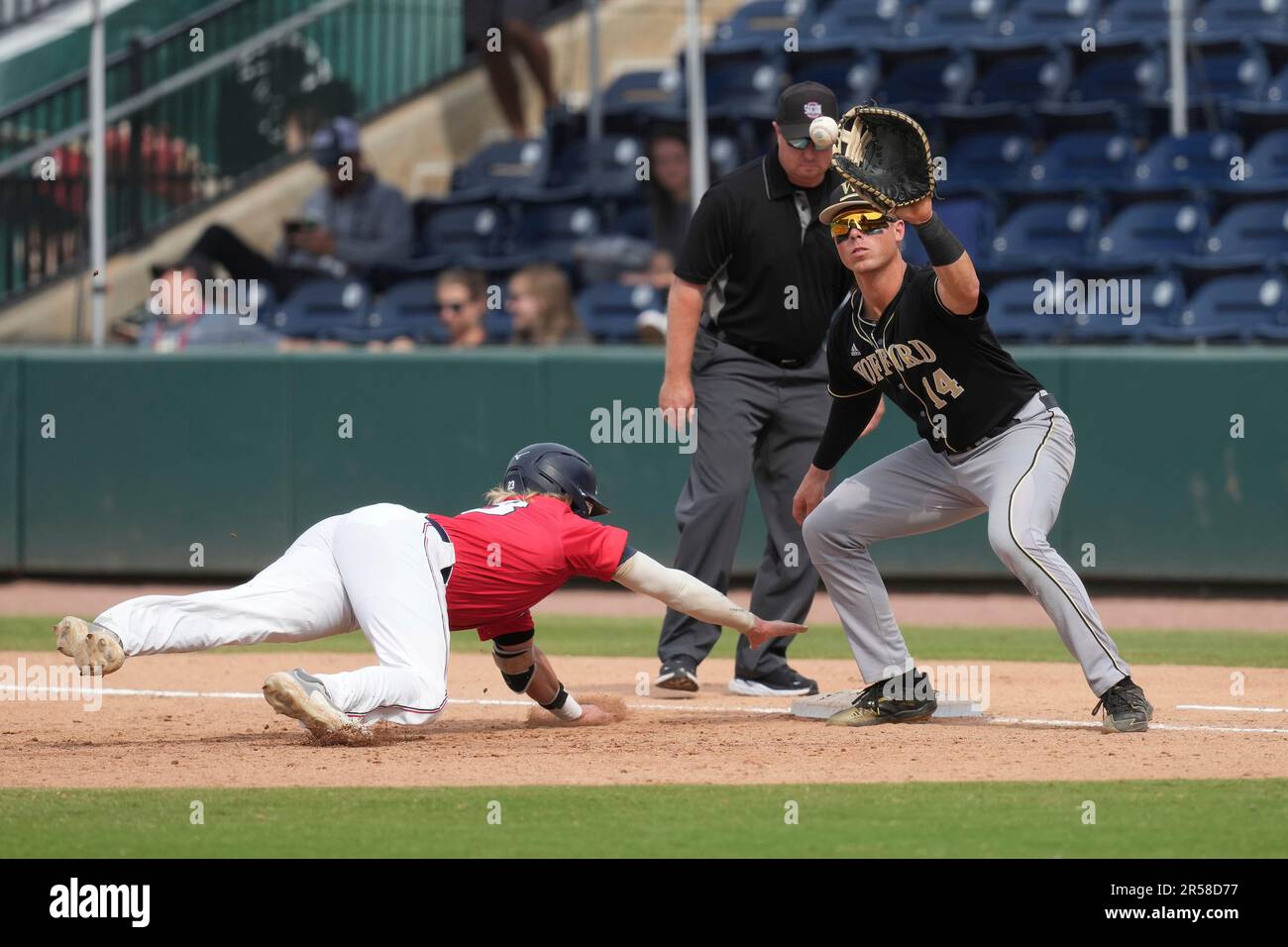 First baseman Ryan Galanie (14) of the Wofford Terriers takes a pickoff ...