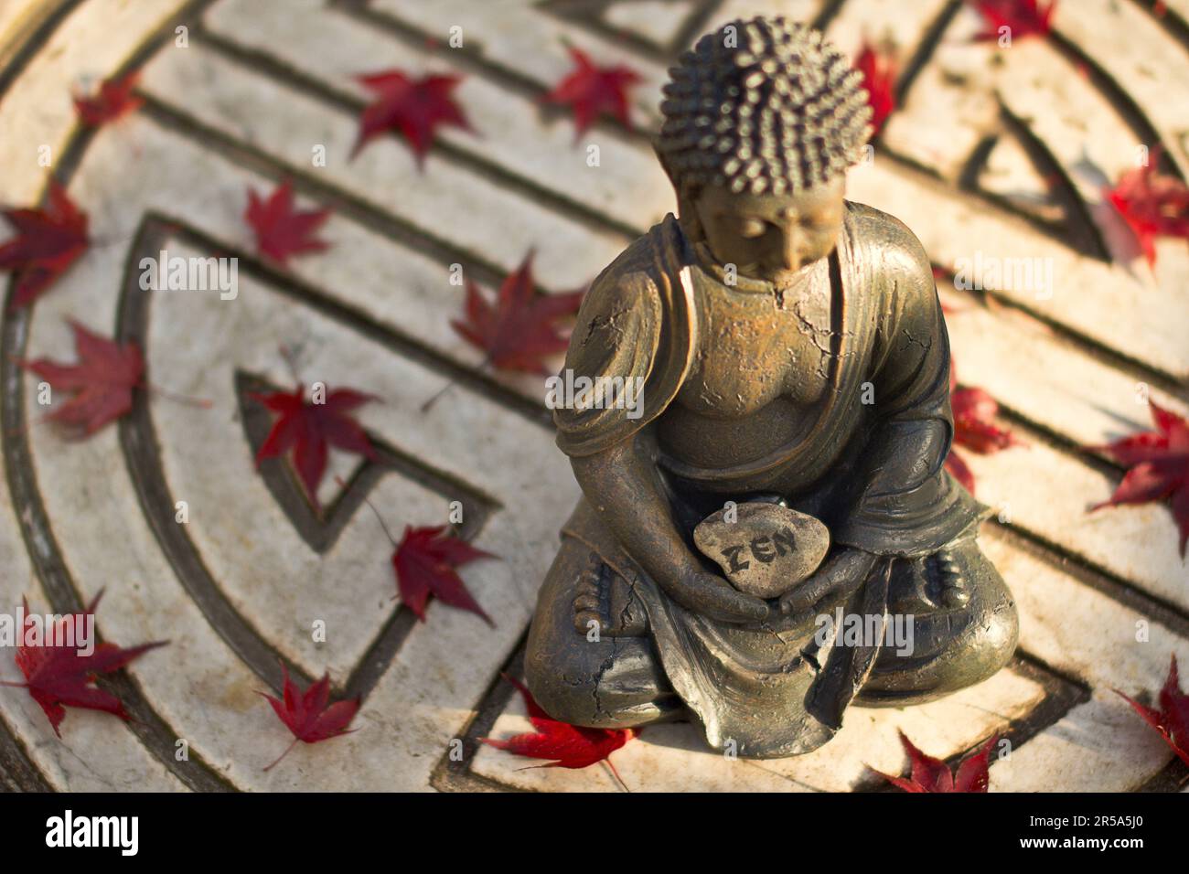 bouddha assis sur le symbole de la vie, dans les mains une pierre ...