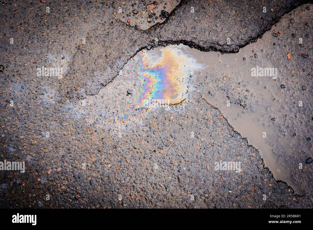 Tache de gaz colorée sur asphalte fissuré humide Photo Stock - Alamy