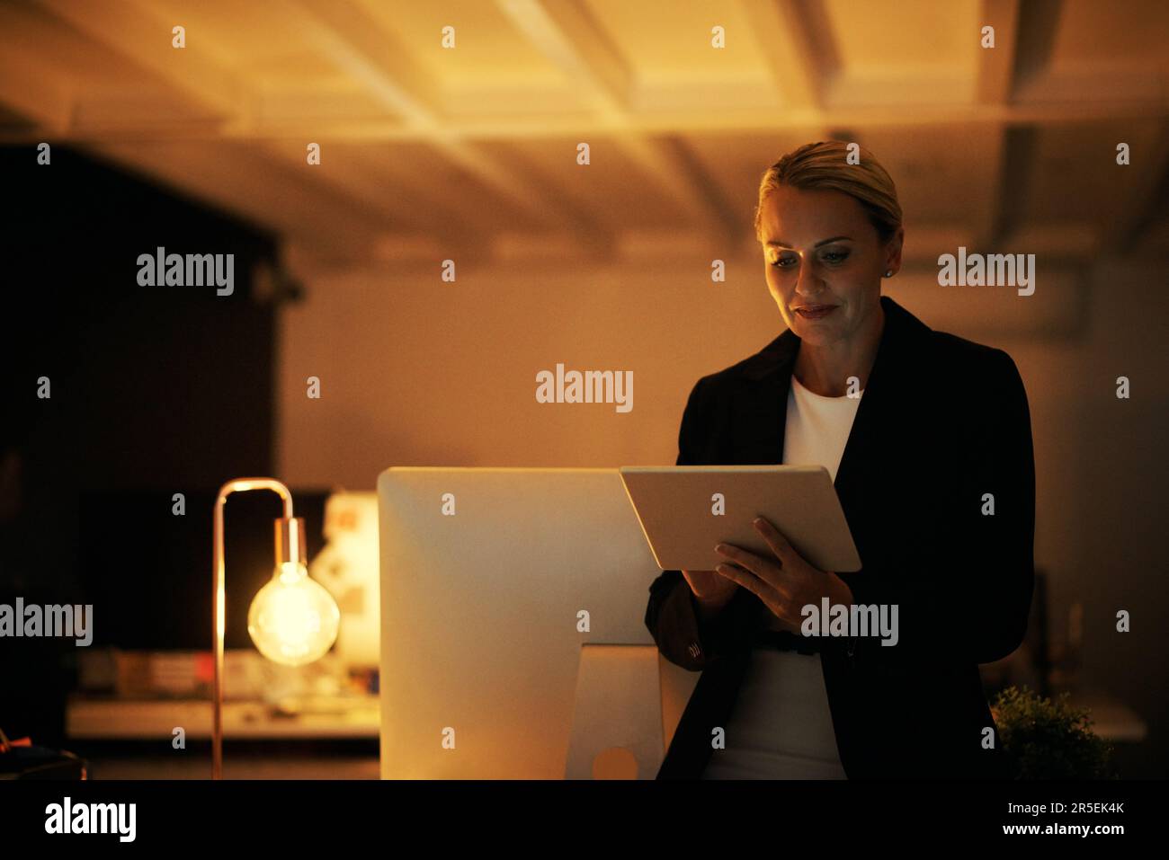 Travailler au-delà des heures de bureau. une femme mûre utilisant sa ...